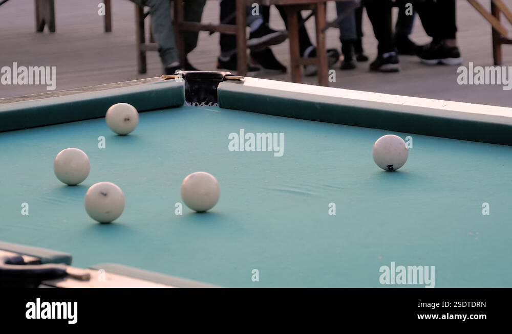 Slow motion: hitting pool ball on teal billiards table - close up Stock ...