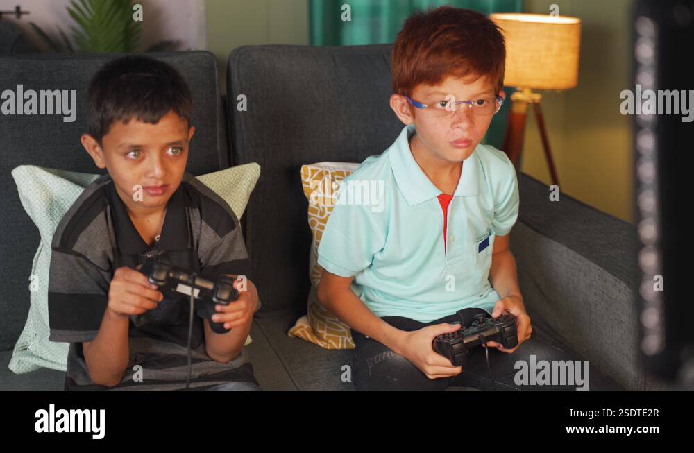 Two kids is playing video game at night in room and one kid suffering ...