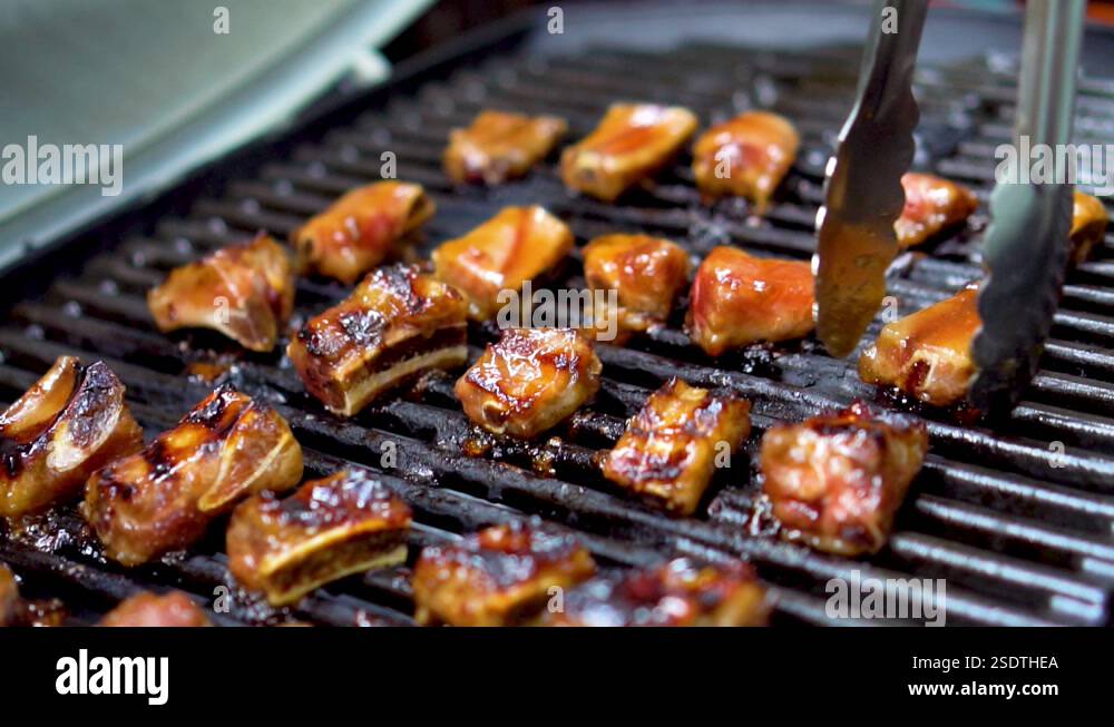 Turning basted short ribs on BBQ Stock Video Footage - Alamy