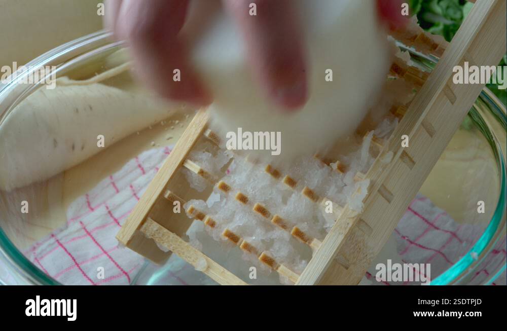 Grating daikon radish with traditional japanese bamboo grator Stock ...