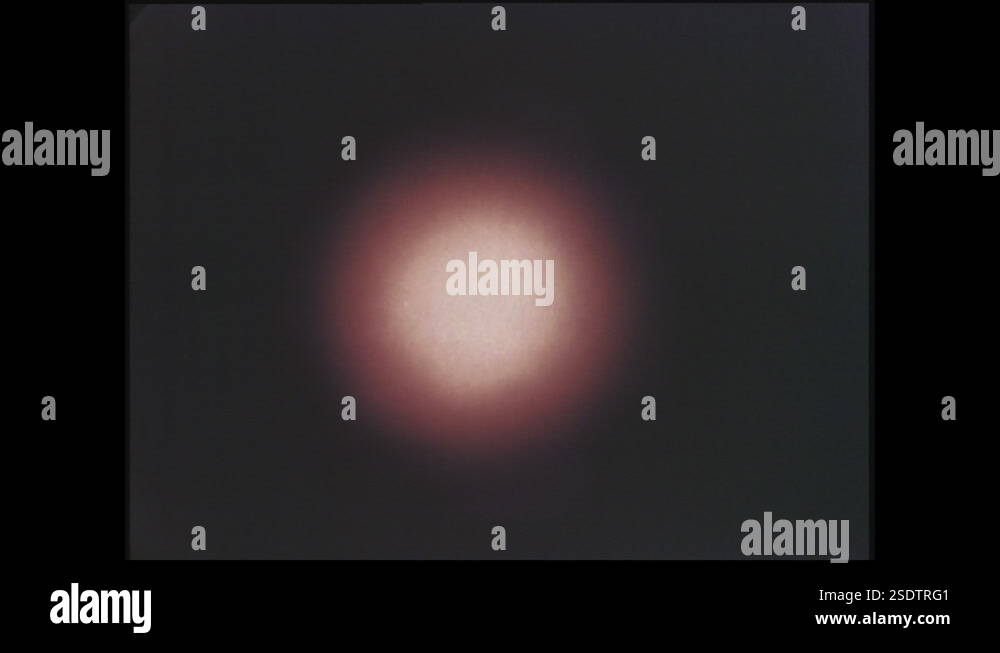1970s: Blurry image of old, dying sun swells, radiates light, collapses ...