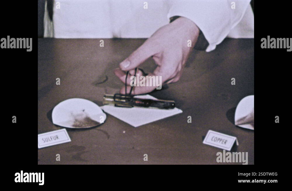 1950s: Person holds test-tube over flame in lab. Person smashes test ...