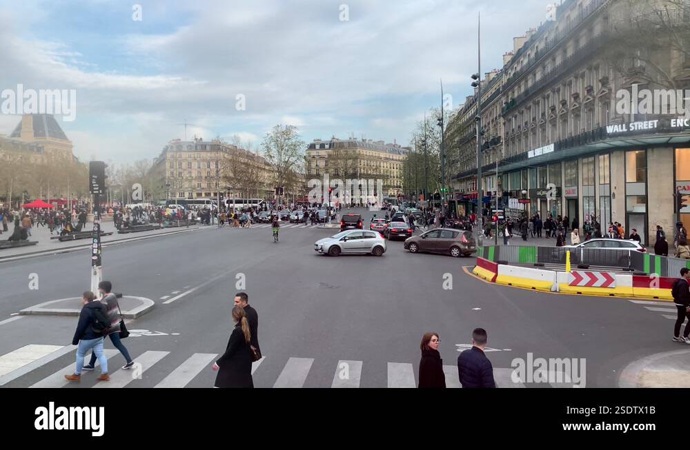 Traffic and pedestrians on an intersection in Paris, France seen from a ...
