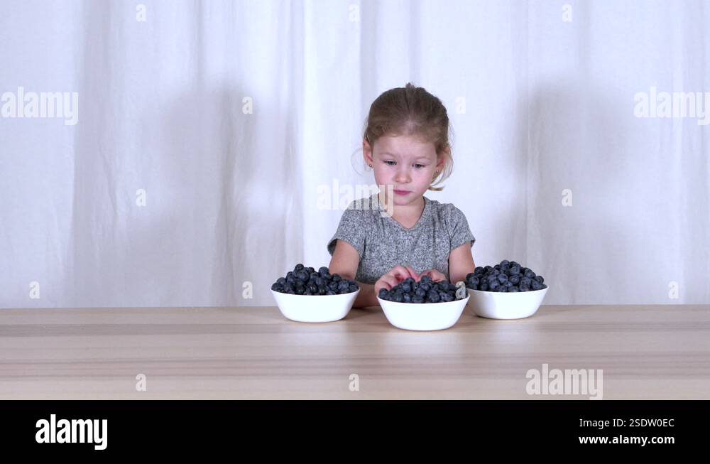 girl is eating berries. Lots of blueberries and blueberries. Healthy ...