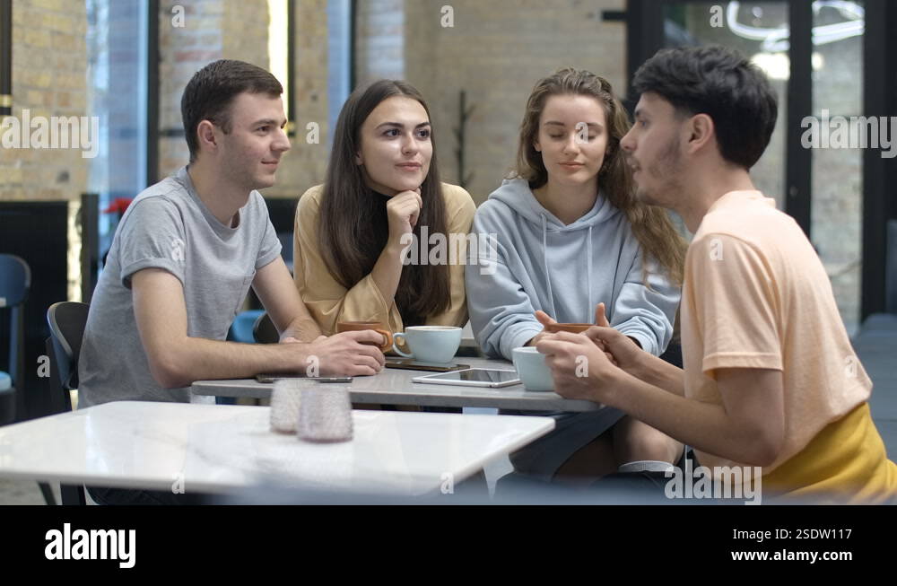 Concentrated young Caucasian friends listening to man talking. Group of ...