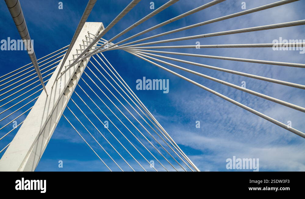 Pylon of a cable stayed bridge under fast moving white clouds in blue ...
