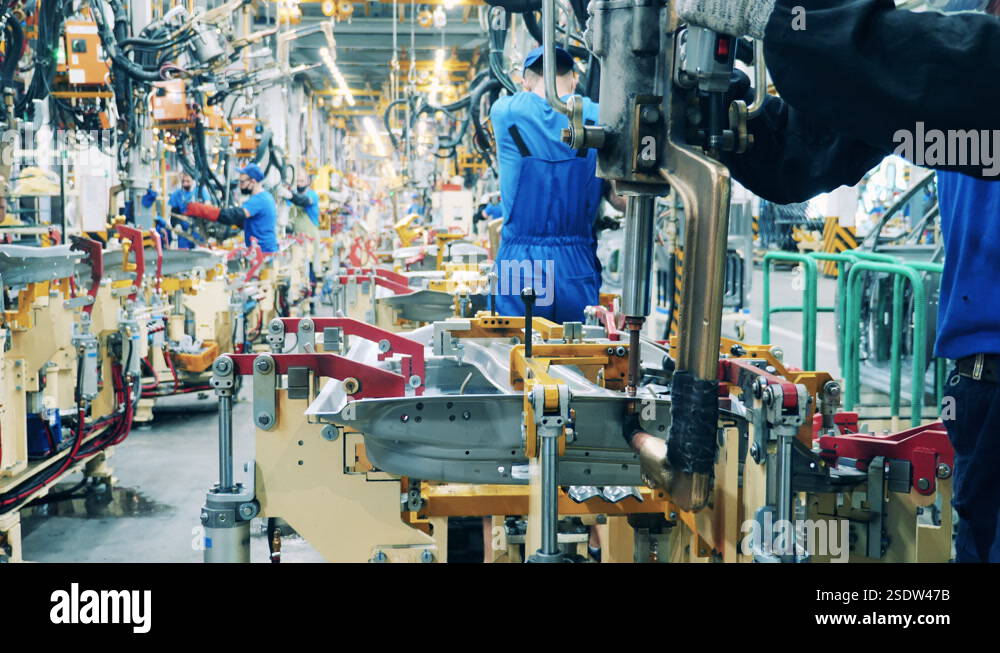 Car factory workers welding a car part using a modern machine Stock ...