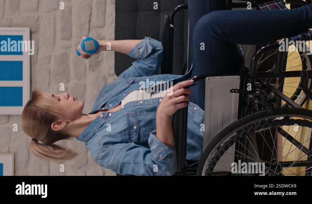 Sad disabled woman in a wheelchair alone in the living room at home ...