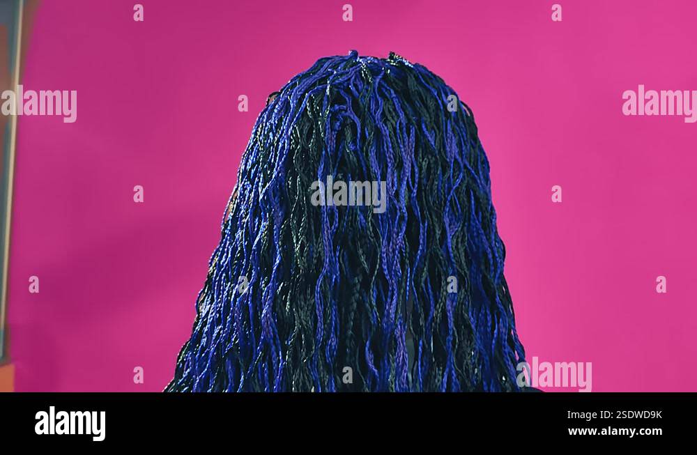 Rear view of a Jewish woman with blue Afro braids turns her face with a ...