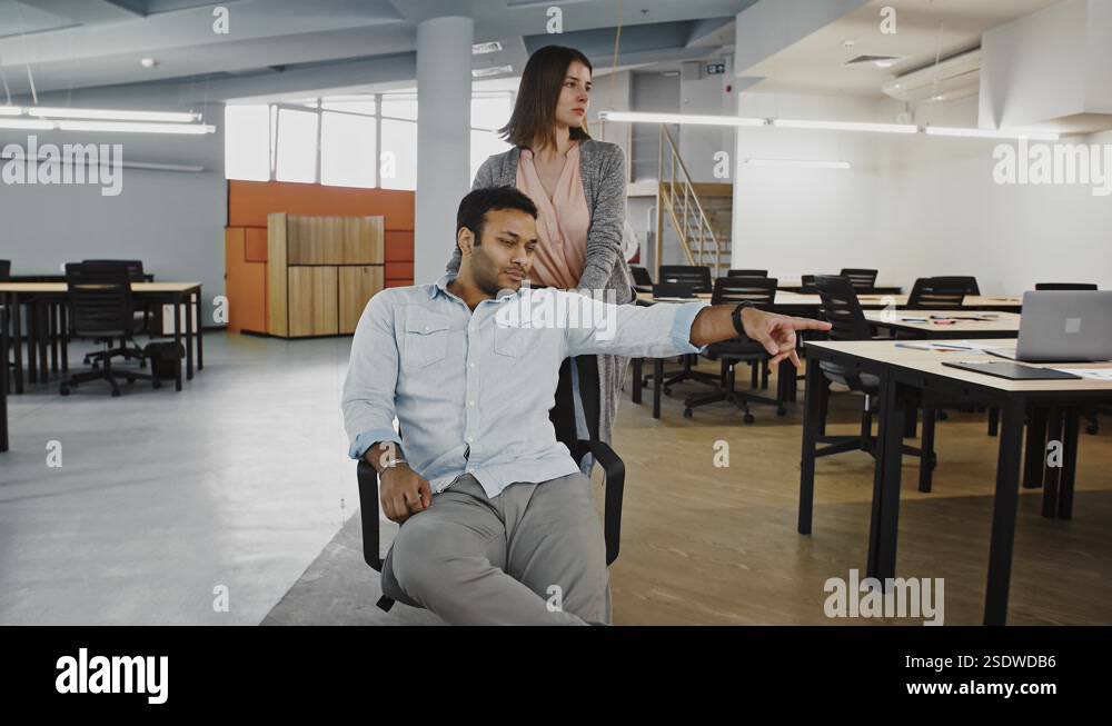 Female pushing chair with her colleague, team of diverse employees ...