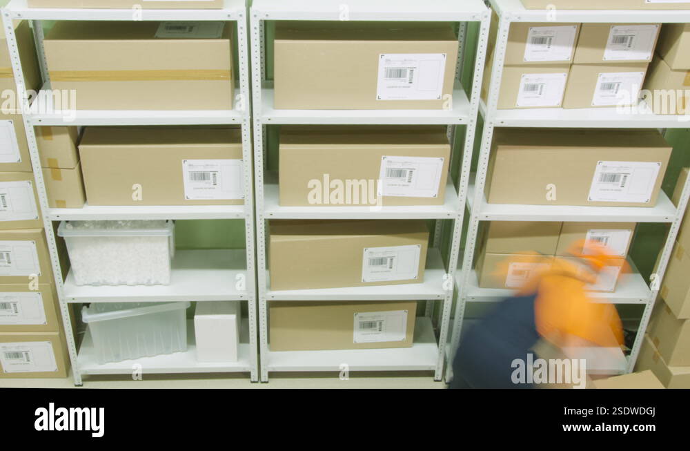 Time lapse of a warehouse worker sorting boxes on the shelves ...