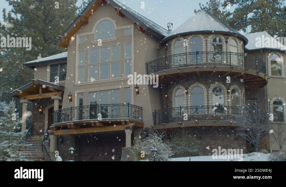 Heavy winter snowfall outside luxurious large mansion stylish exterior ...