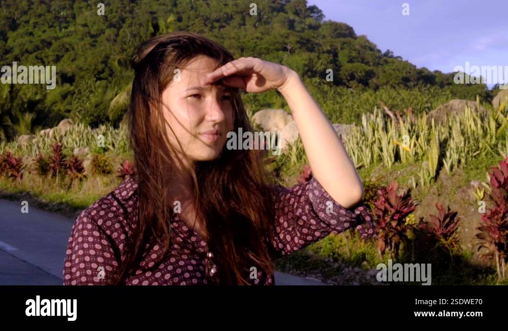 Beautiful young woman on nature wind blows long hair windy weather ...