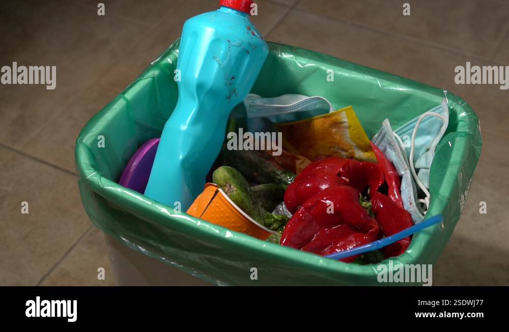 A woman throws stale uneaten spoiled vegetables, expired food and ...
