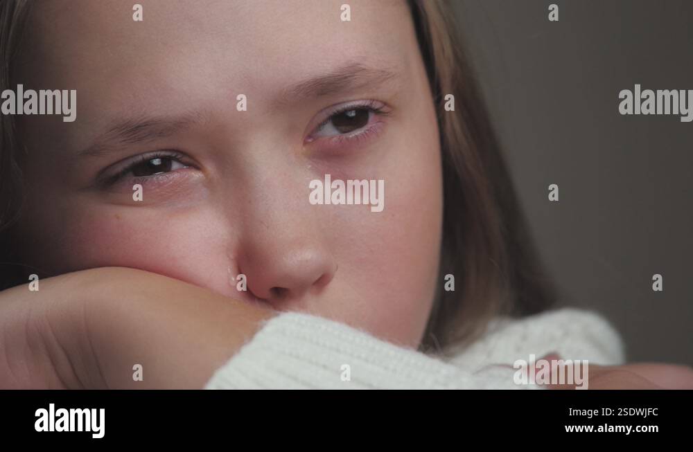 A teenage girl cries and tears run down her cheeks. The child is upset ...