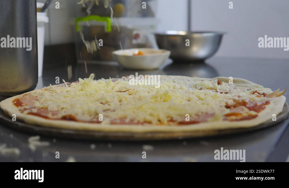 Male hand of cook throwing grated cheese on pastry with fresh ...