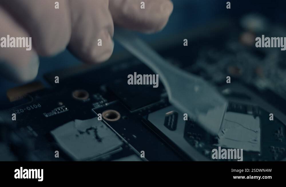 GPU Graphic card. Macro view of technician's hand spreading new thermal ...