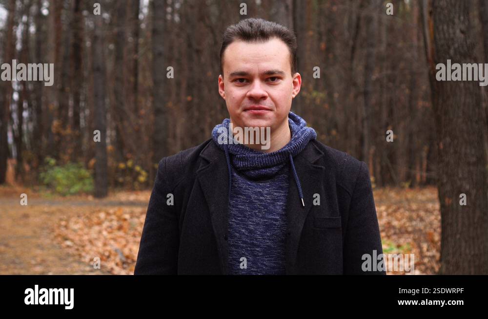 Man looking at camera, saying yes and nods his head in autumn park ...