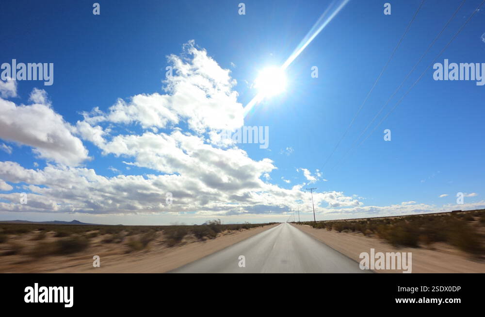 Driving west into the sunshine and cloudscape over the Mojave Desert ...