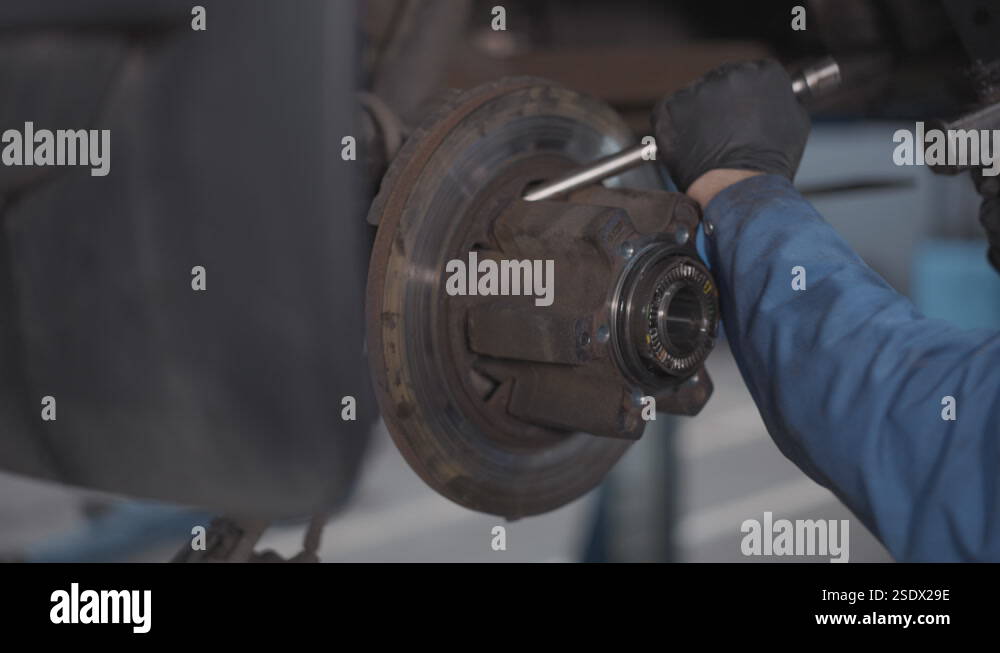 Close-up of unrecognizable repairman using hammer and chisel in car ...