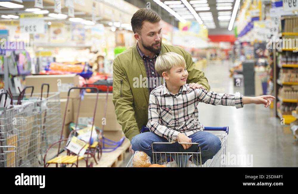 Kid boy point finger at side in store during shopping with father Stock ...