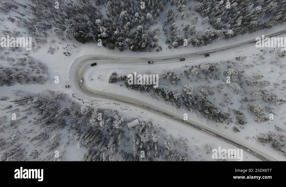 Steady areal footage of a curved mountain road with car traffic in ...