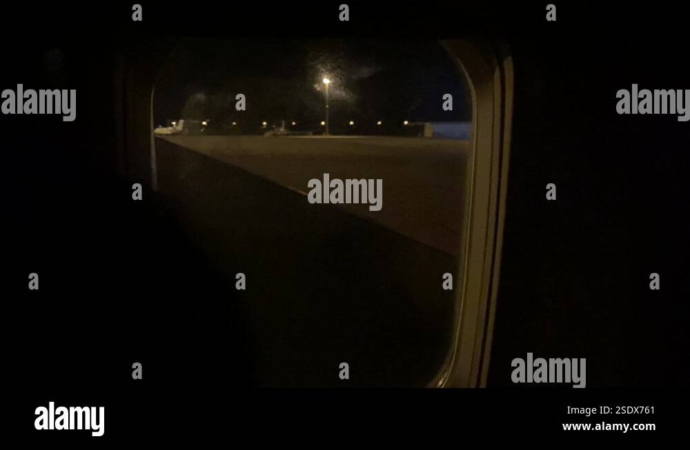 Airplane doing maneuvers on the landing strip at the airport at night ...