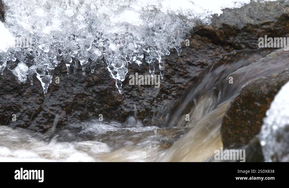 natural ice formation icicles on rock in natural stream of water Stock ...