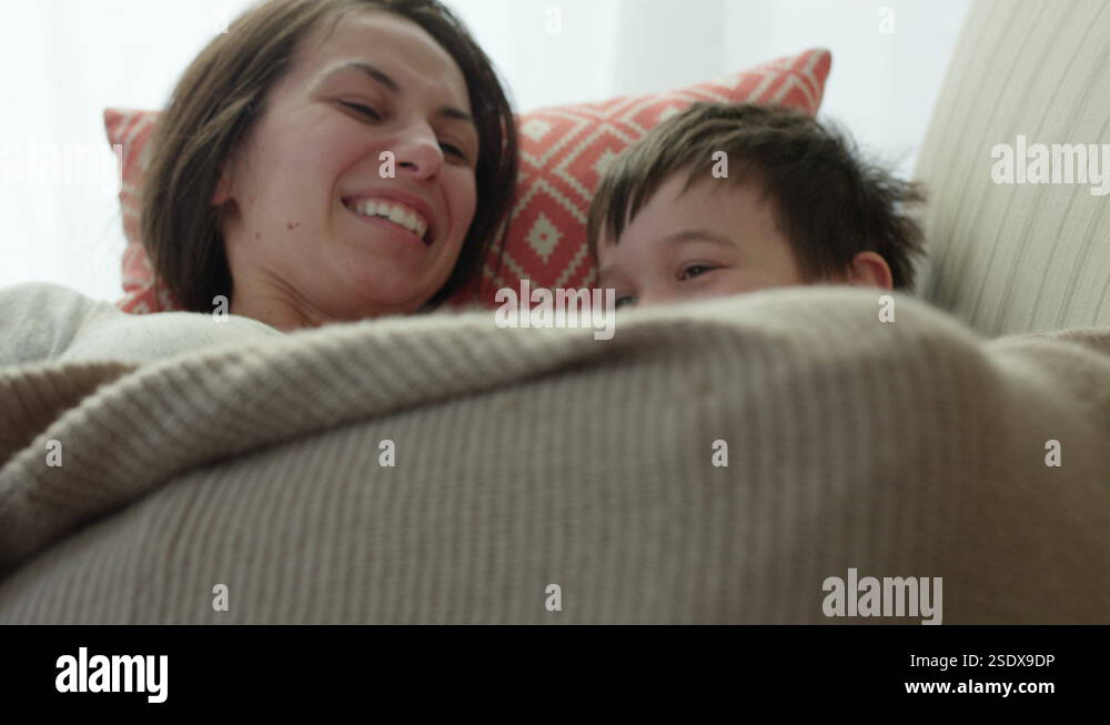 Mother and young son cuddle up on couch for afternoon nap - close up on faces Stock Video ...