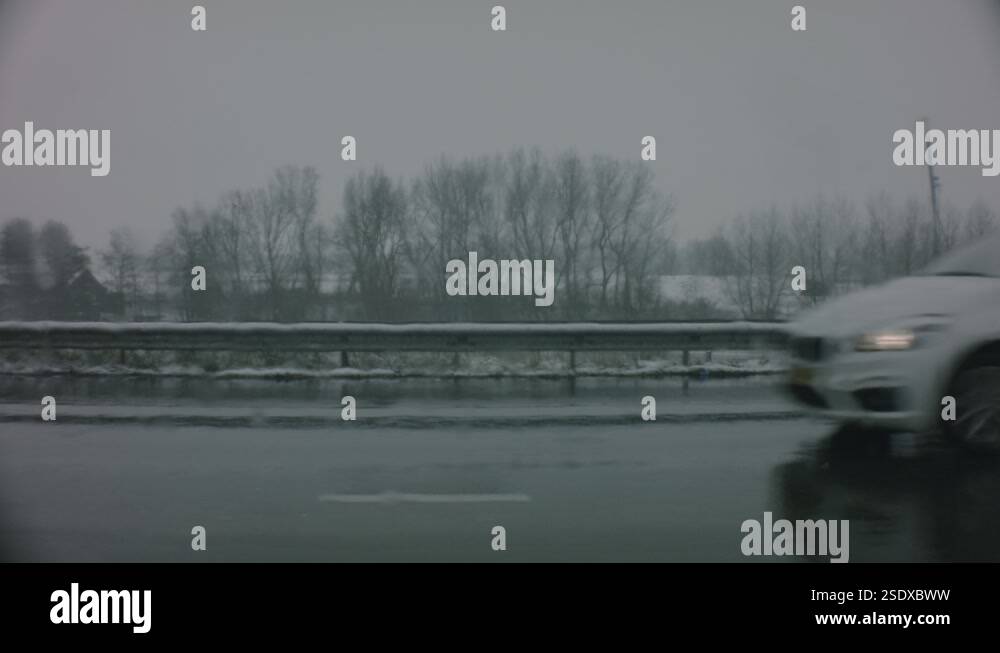 still shot in a vehicle in winter raining day over a wet rainy window ...