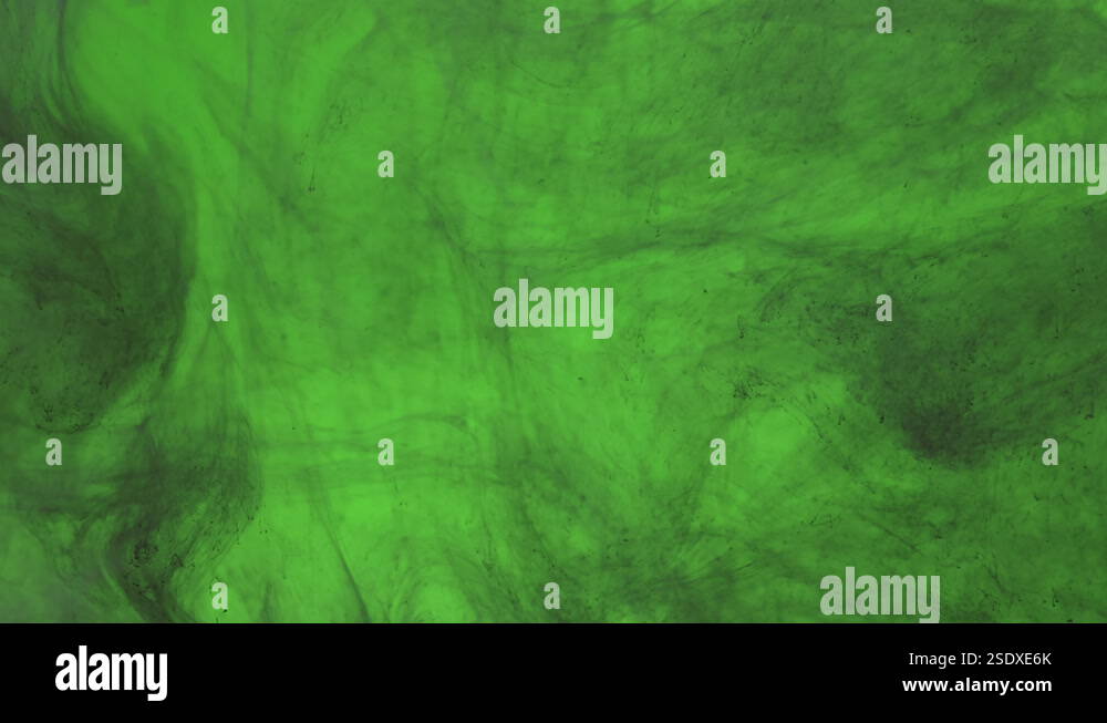 Black paint particles floating in water against a green screen Stock ...
