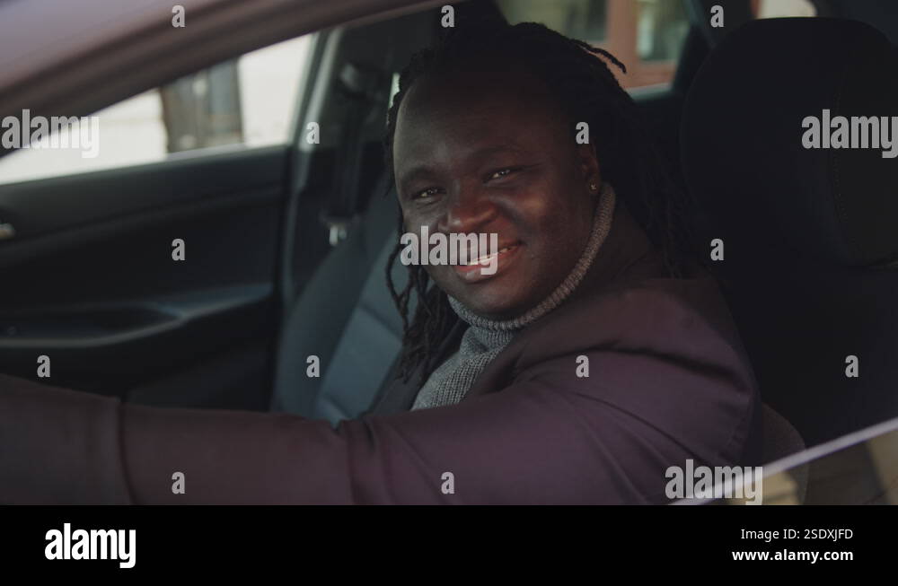 Happy african american black man sitting on the drivers seat of his new ...