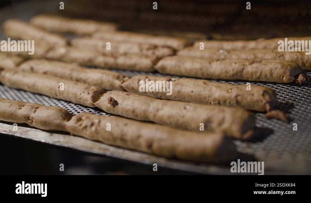 View of process of baking bread sticks on plates in professional oven ...