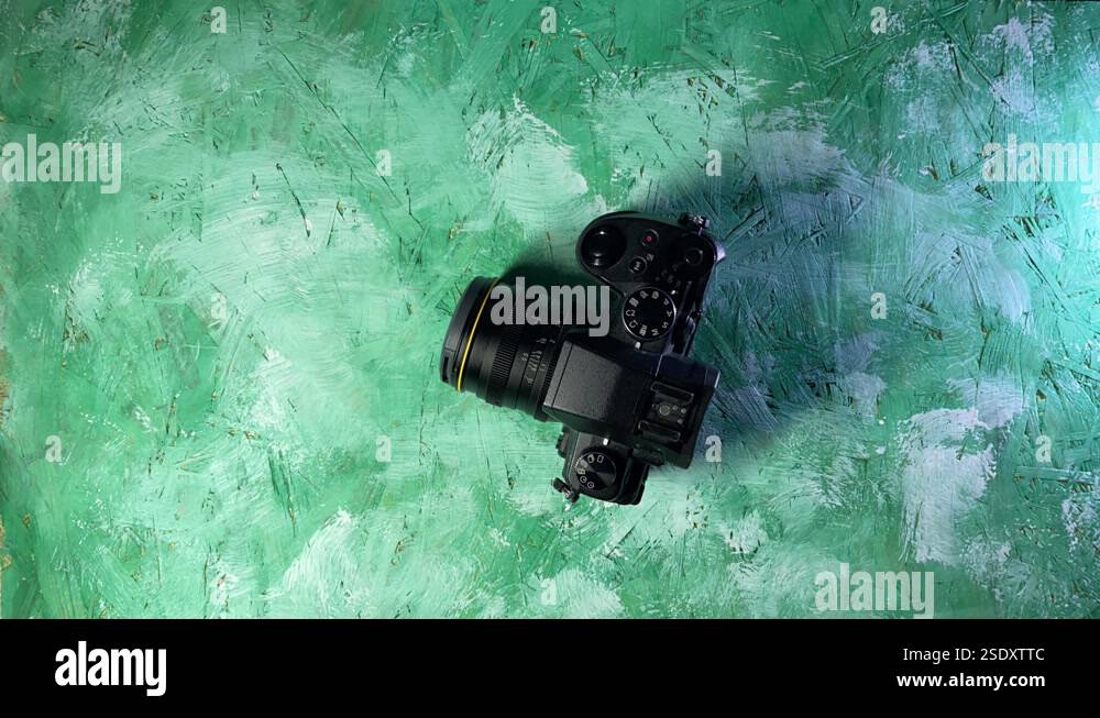 DSLR Camera Spinning And Opens Screen In Green Table. - top view, stop ...