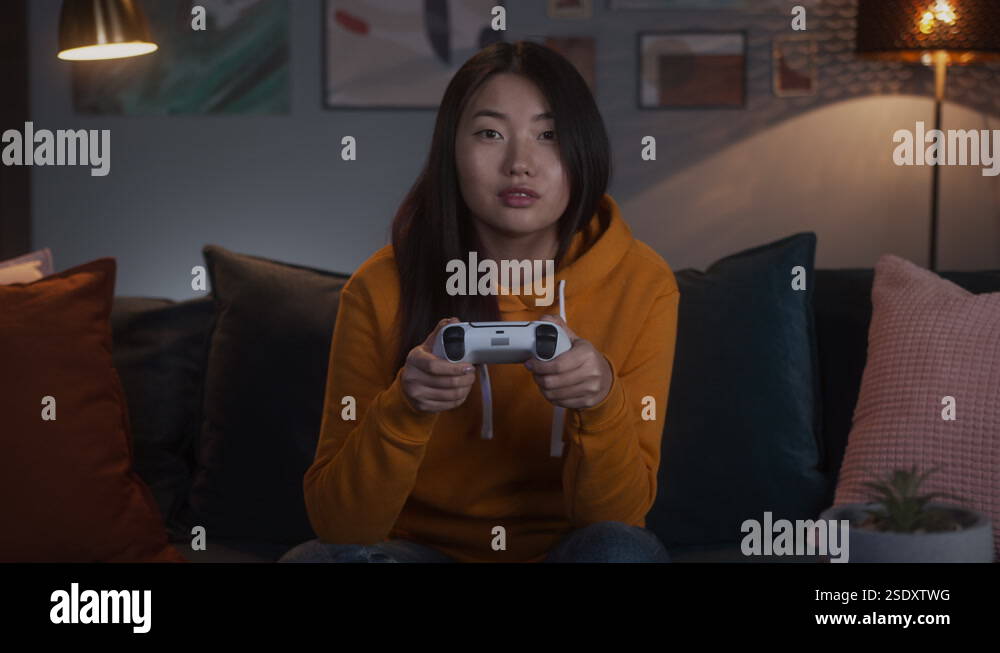 Excited woman playing video games on modern next gen console with ...