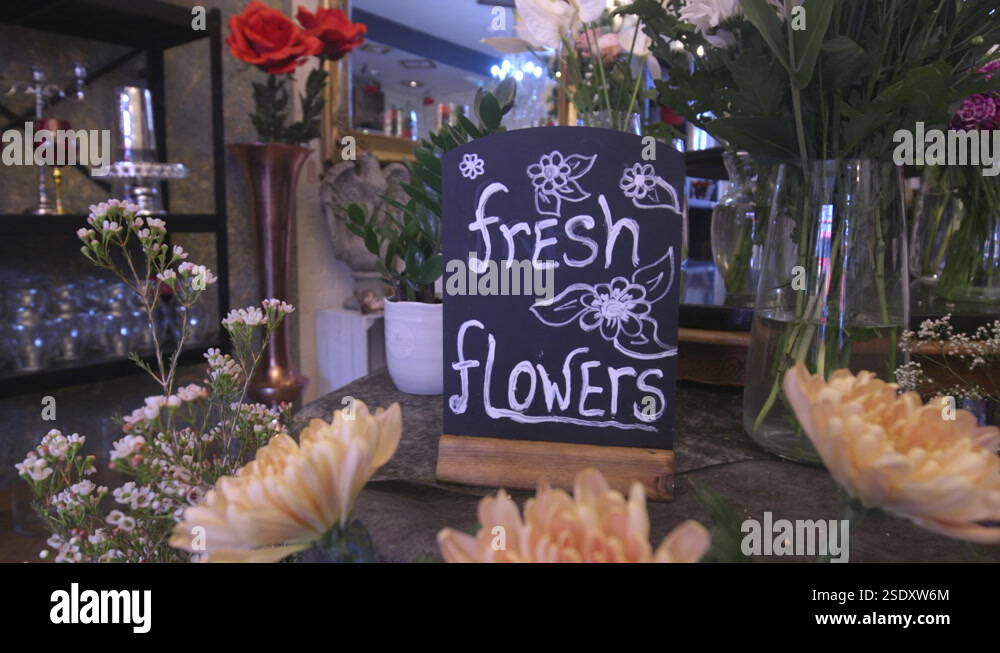 fresh flowers hand written sign surrounded by flowers and decor Stock ...