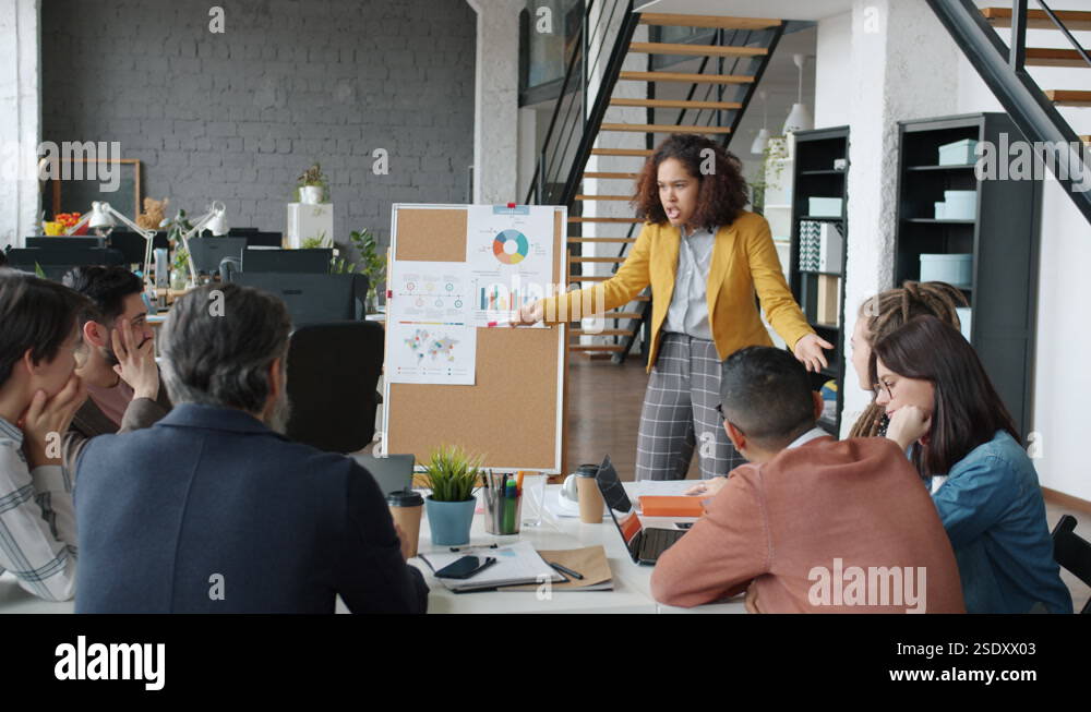 Angry African American woman yelling at employees pointing at board ...