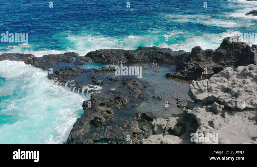 People enjoying pure nature. Aerial 4K people swimming at ocean tide ...