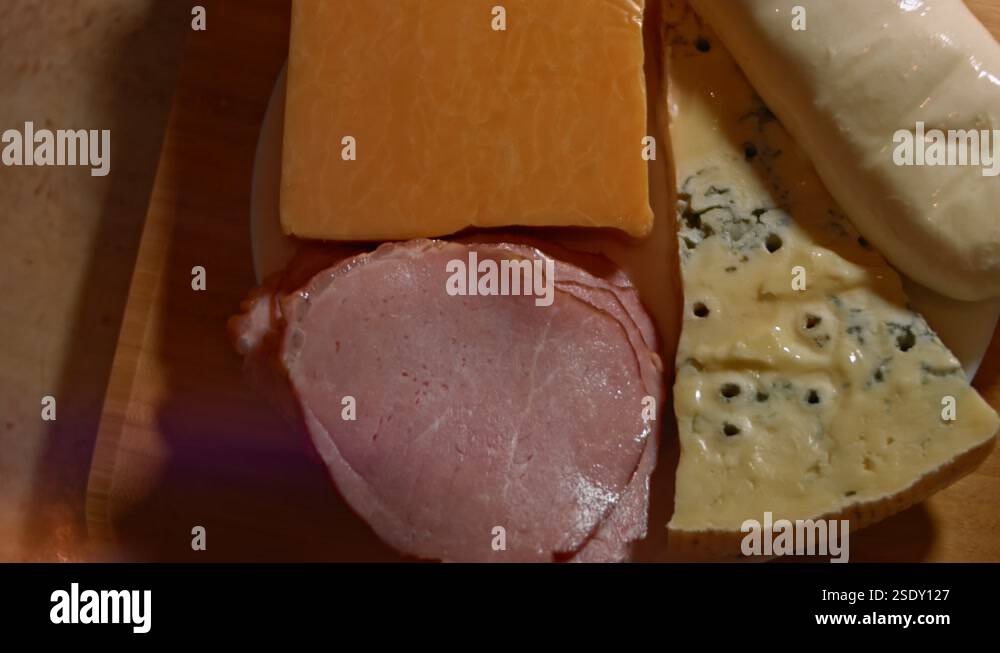 Various types of savory and fresh cheeses and pork ham ready to be cut ...