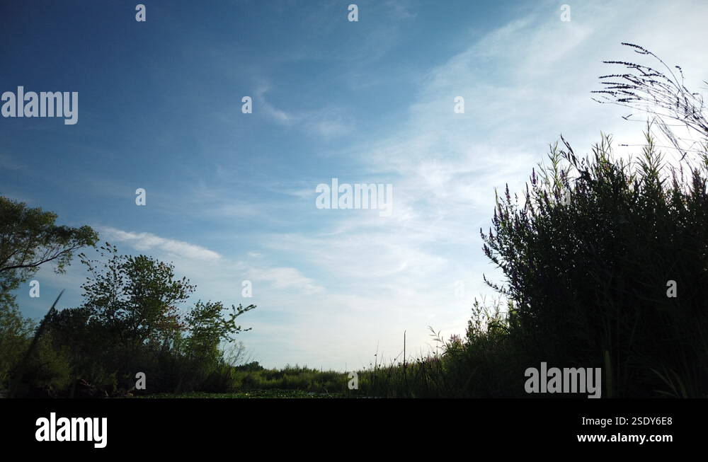 A motion time-lapse of the sky, fast moving clouds, and reveal of a ...