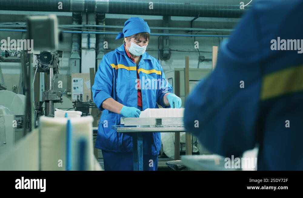 Female factory workers placing paper tissues onto a conveyor Stock ...