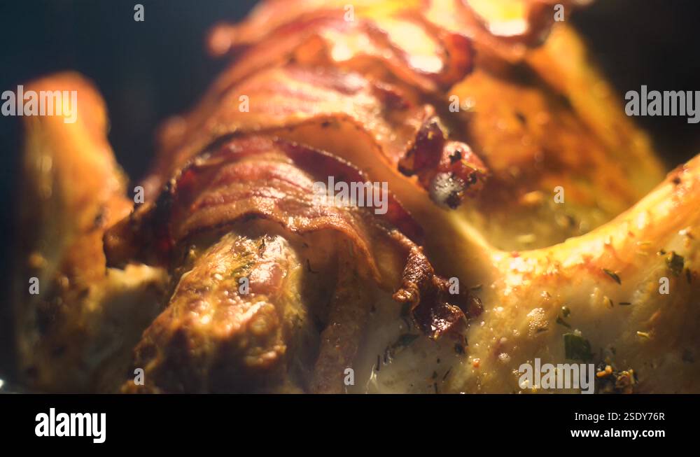 Delicious looking turkey covered in bacon roasting in oven during Stock ...