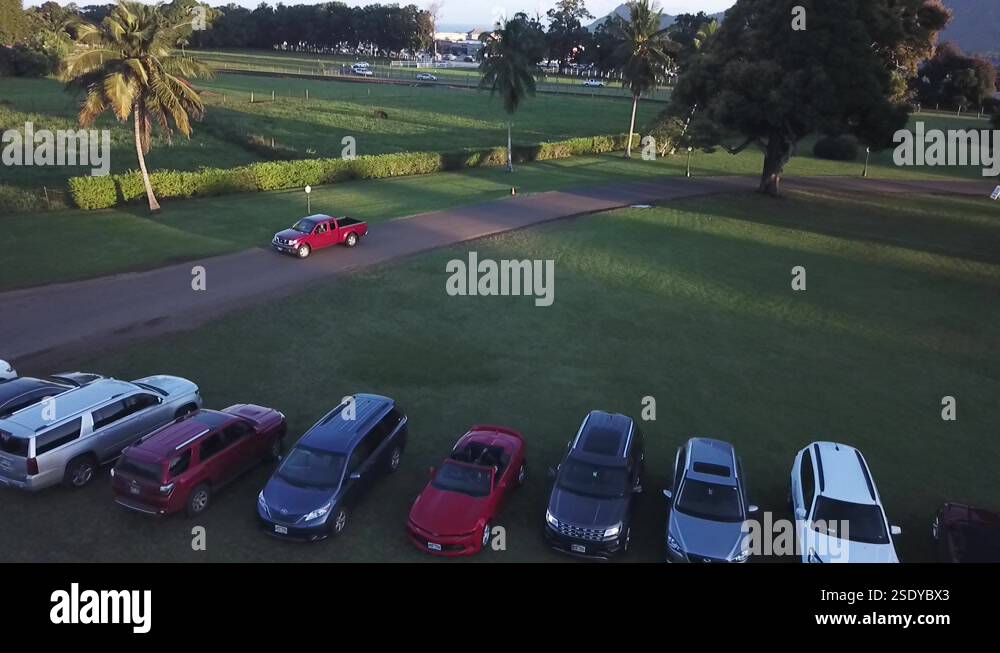 Row Of Cars Parked On Green Grass At The Park In Kauai, Hawaii During ...