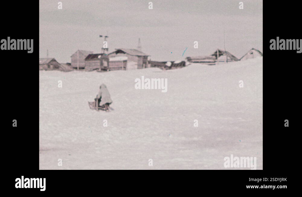 1960s: person pushing sled over snow to town, weather map of cold front ...