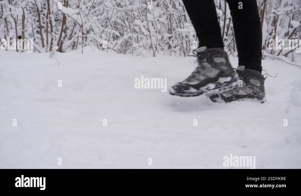 Female walk on snow with hike shoes, slow motion truck side slide ...