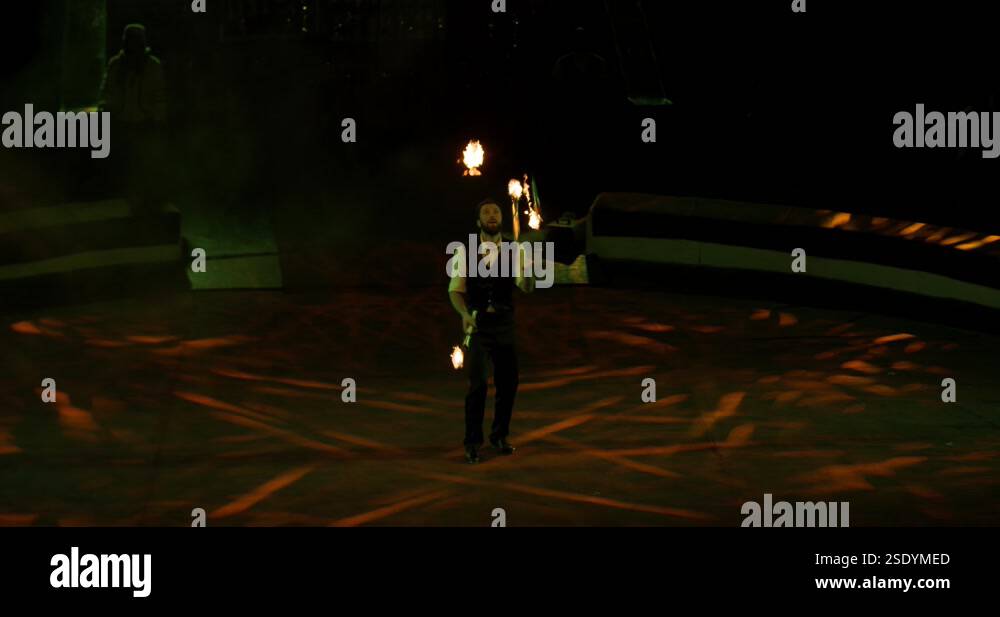 Amazing juggler is performing on stage with torches, dangerous ...