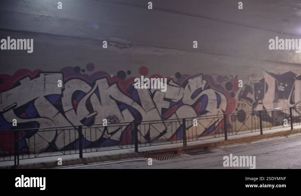 Road under a bridge , pan footage at night. Graffiti on the walls 4k ...