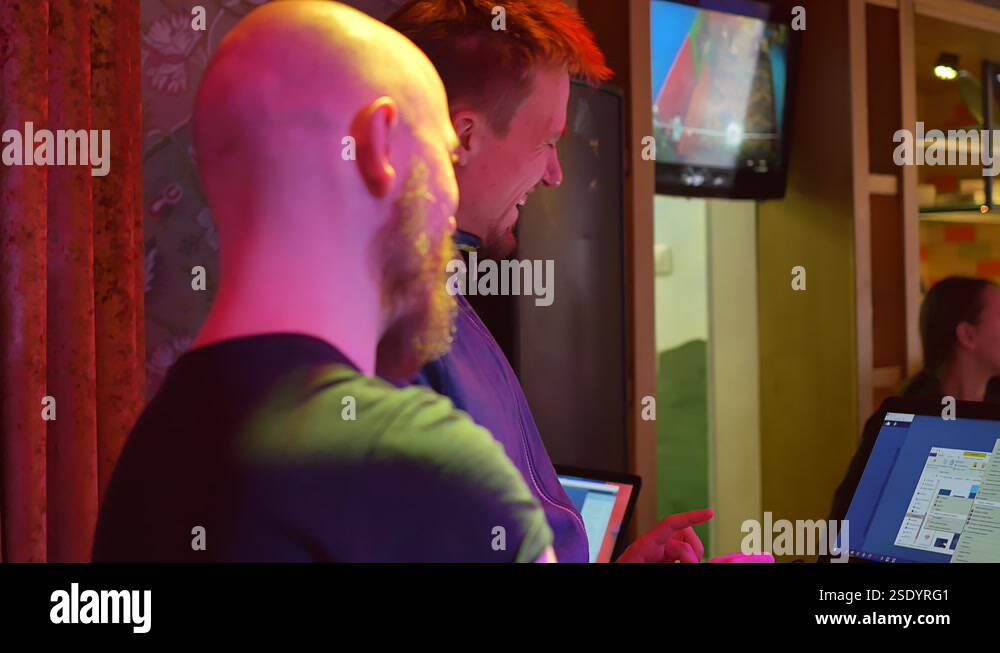 Two guys stand talking about work, watching a laptop screen, and then ...