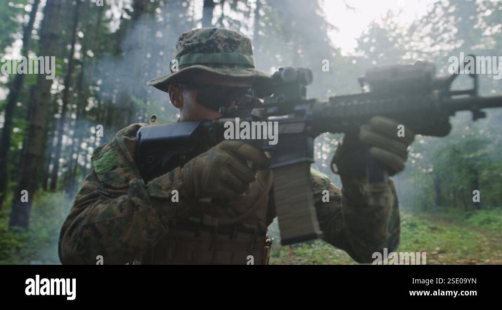 Soldier taking aim from rifle in forest, smoke in background, military ...
