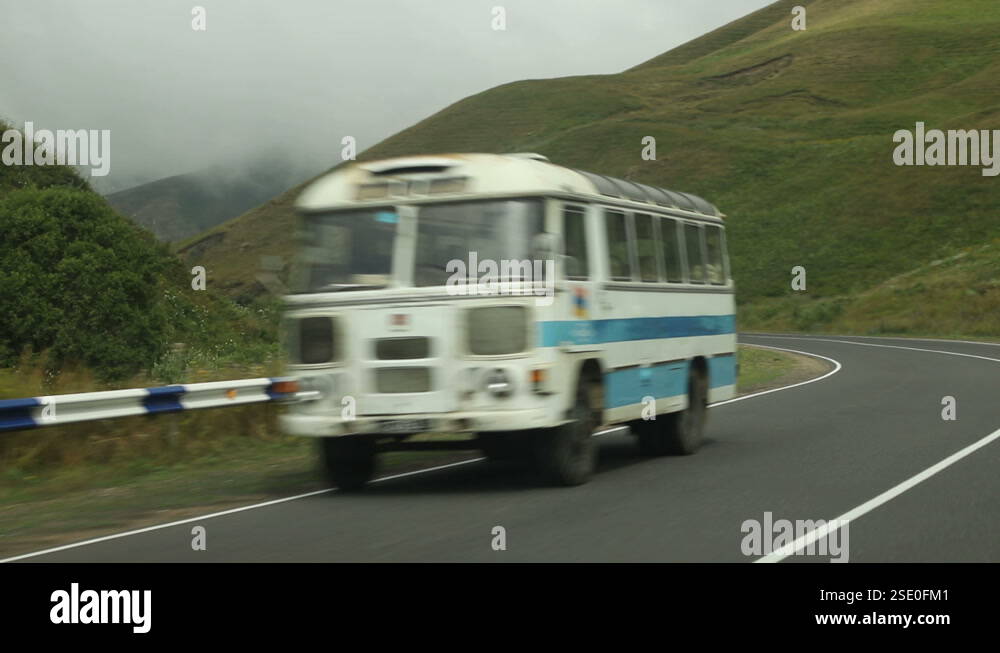 Cars rides on a paved smooth road in the middle of a mountainous area ...